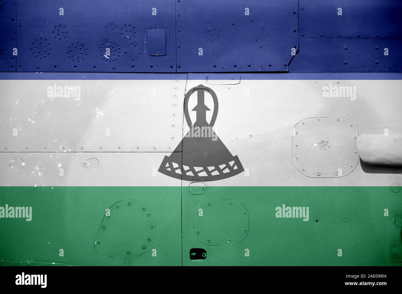 Lesotho flag depicted on side part of military armored helicopter close ...