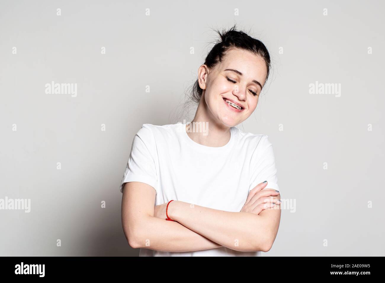 Happy woman sincerely smiles and laughs, closing her eyes with pleasure ...