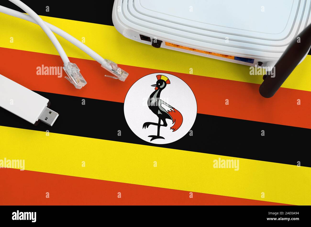 Uganda flag depicted on table with internet rj45 cable, wireless usb wi ...