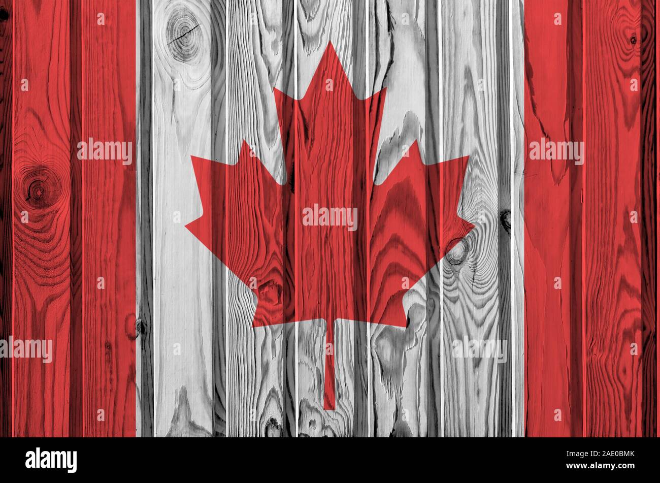 Canada flag depicted in bright paint colors on old wooden wall close up ...