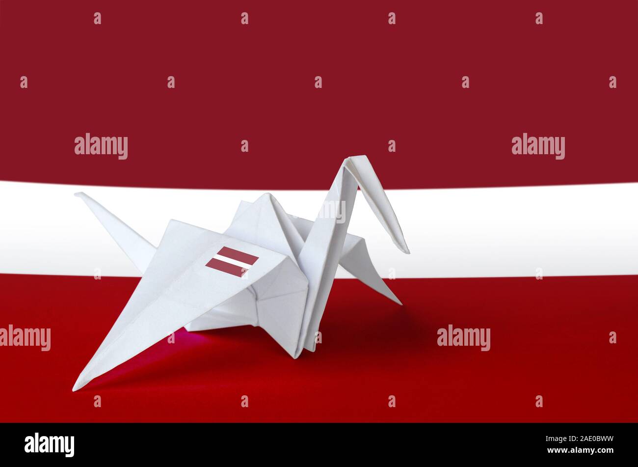 Latvia flag depicted on paper origami crane wing. Oriental handmade ...