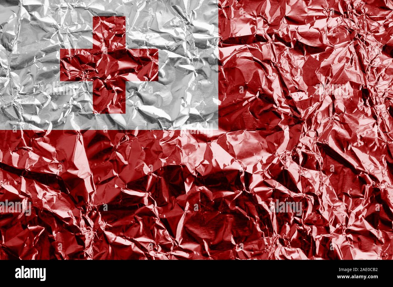 Tonga flag depicted in paint colors on shiny crumpled aluminium foil ...