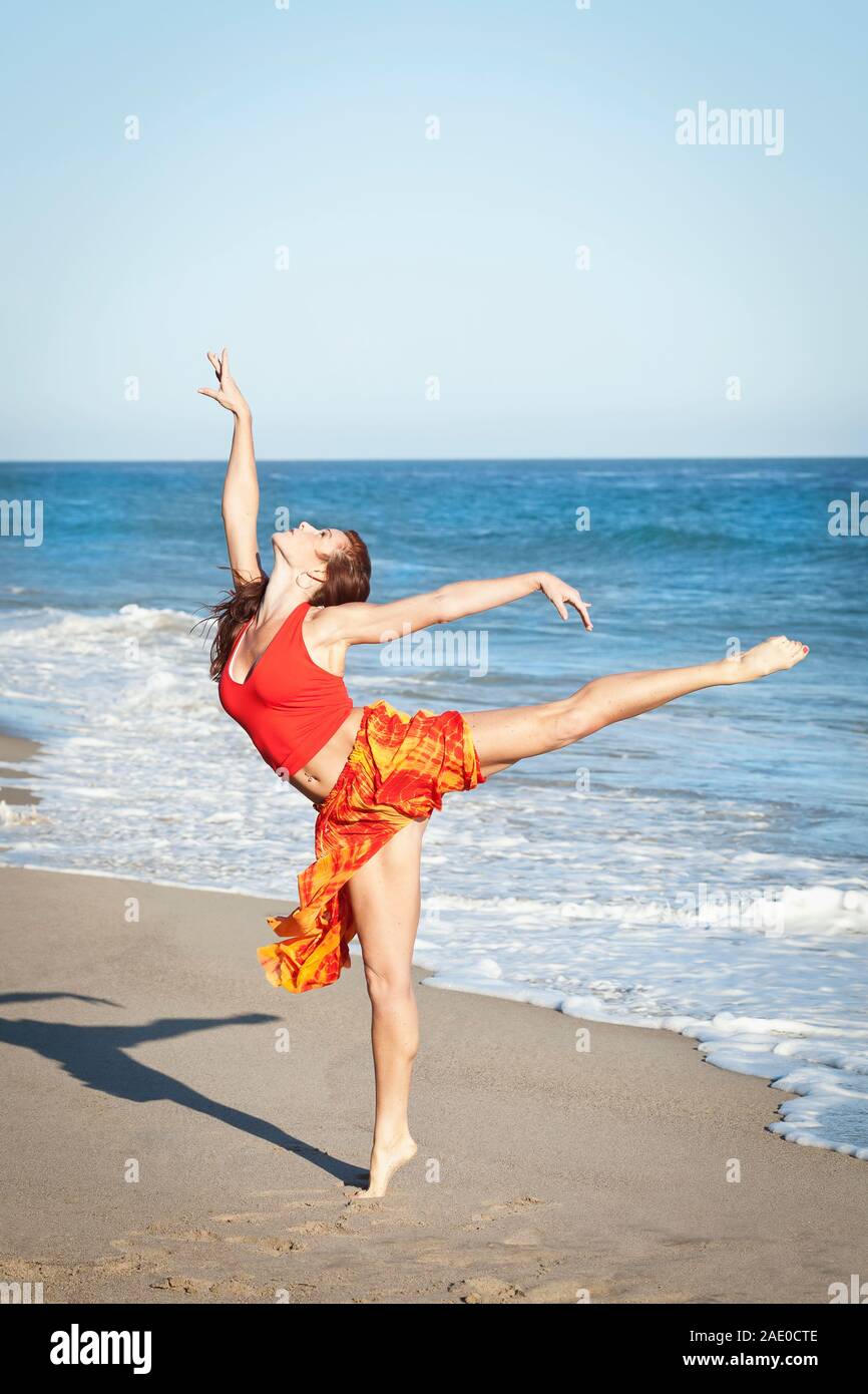 Happy woman dancing alone at the beach Stock Photo - Alamy