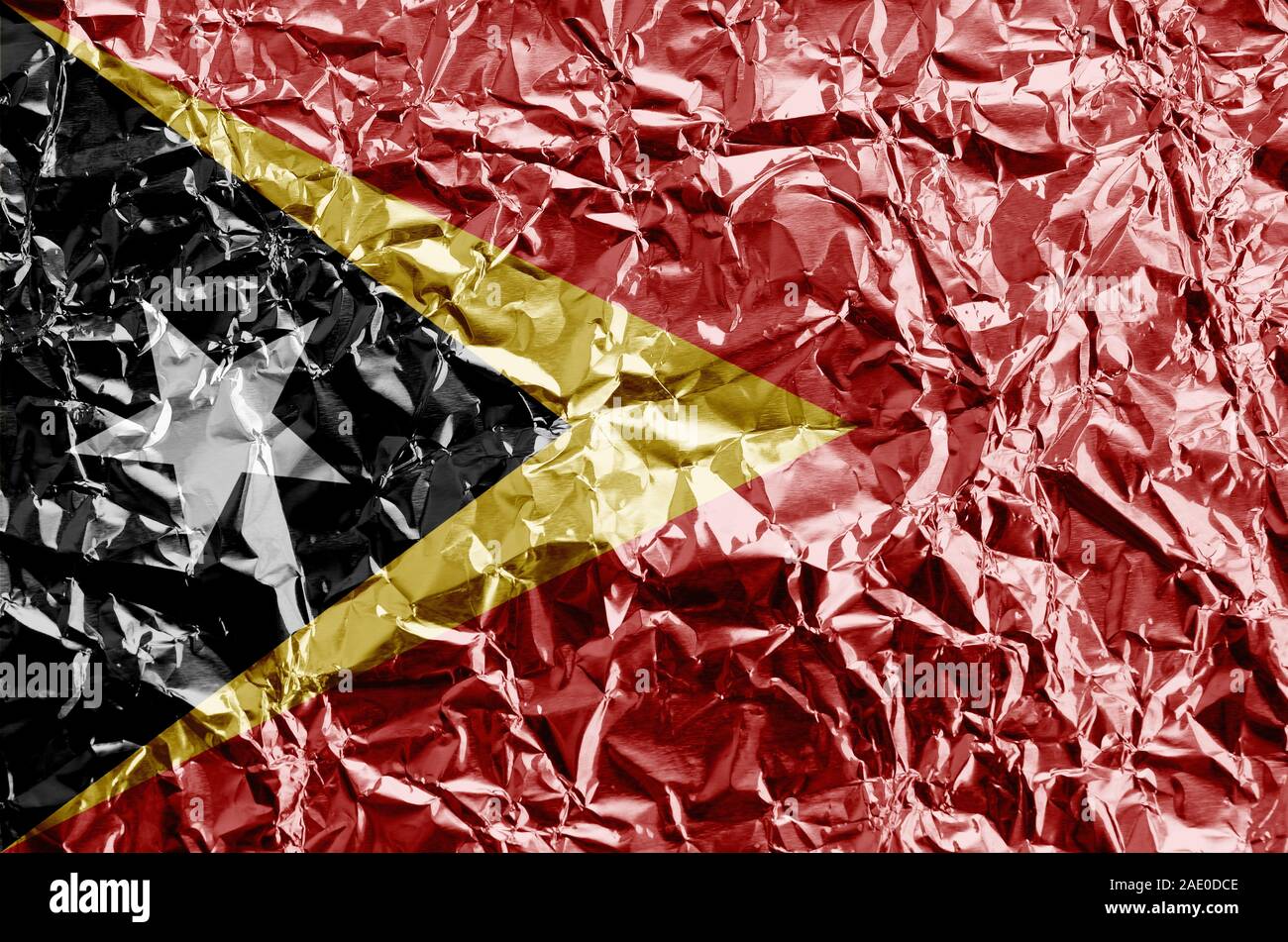 Timor Leste flag depicted in paint colors on shiny crumpled aluminium ...
