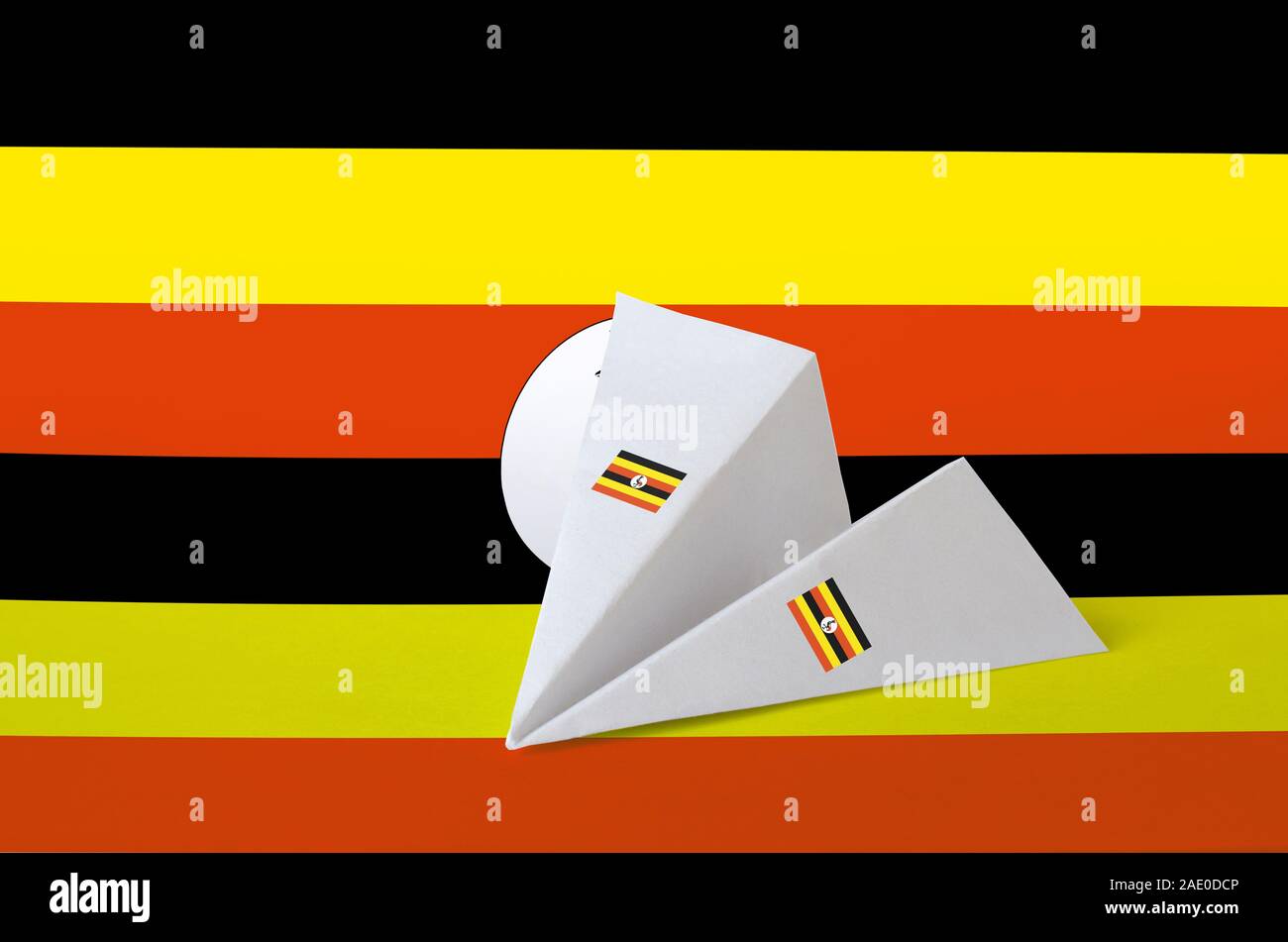 Uganda flag depicted on paper origami airplane. Oriental handmade arts ...