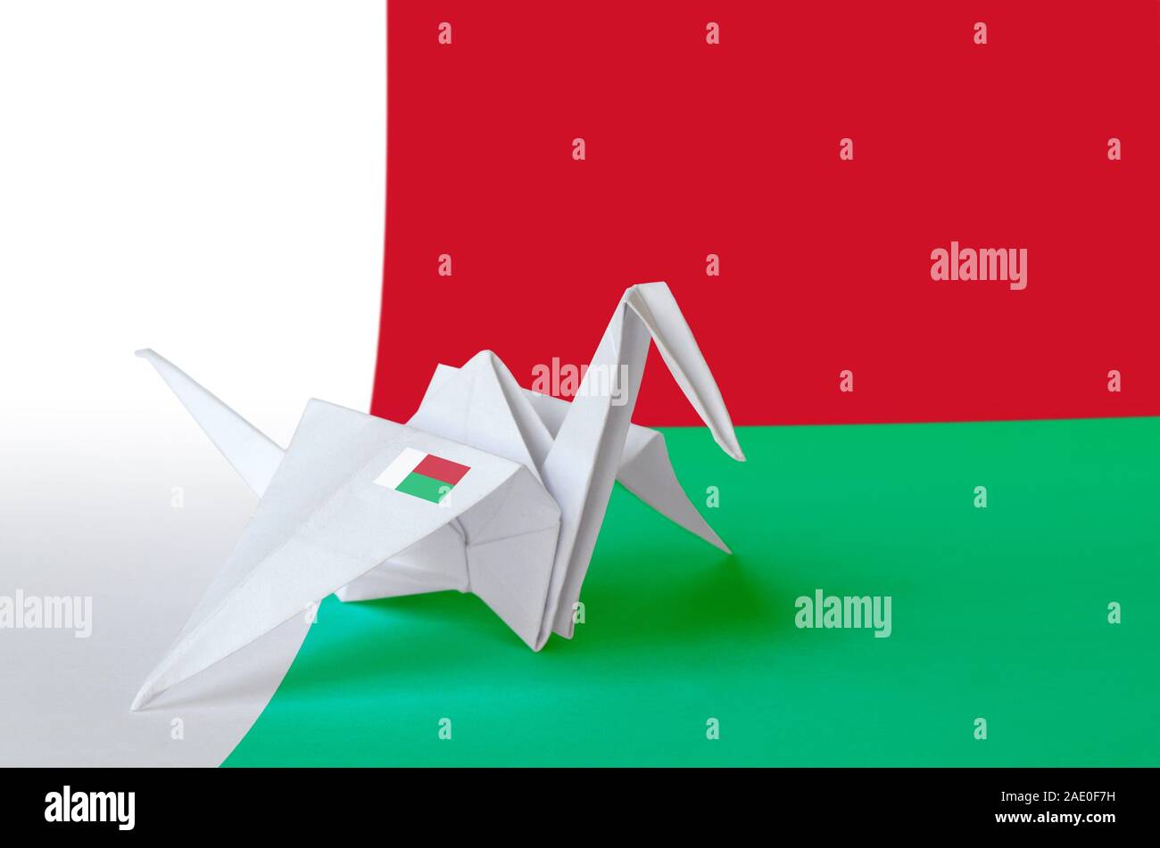 Madagascar flag depicted on paper origami crane wing. Oriental handmade ...