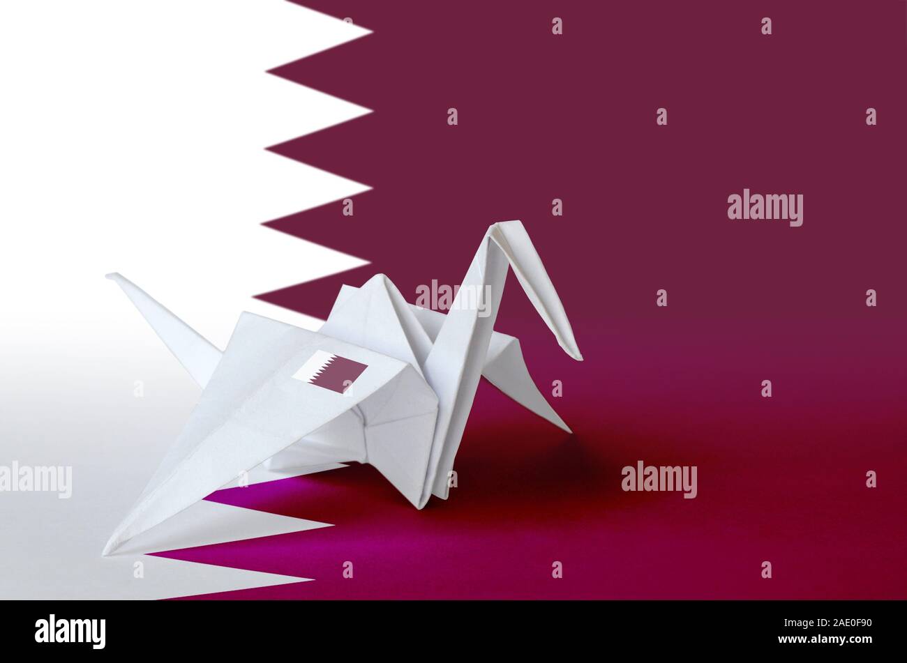 Qatar flag depicted on paper origami crane wing. Oriental handmade arts ...