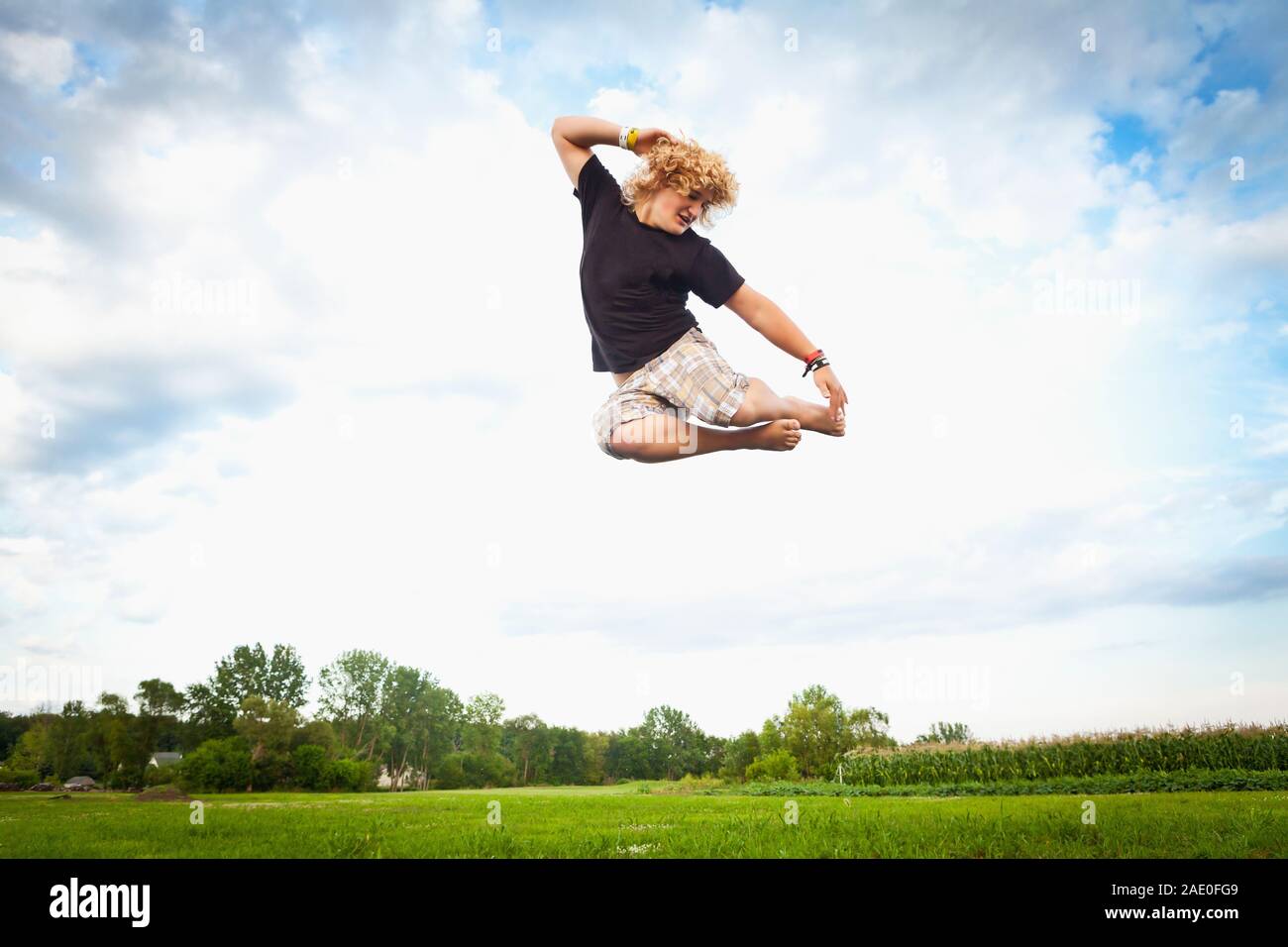 Young man jumping high in the sky Stock Photo - Alamy