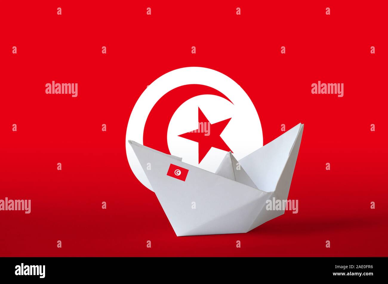 Tunisia flag depicted on paper origami ship closeup. Oriental handmade ...