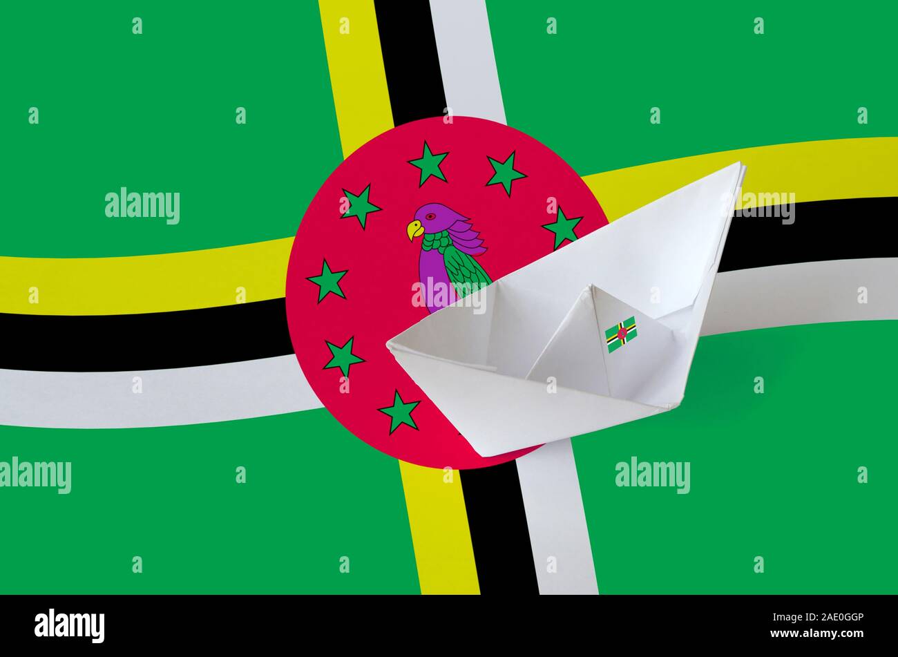 Dominica flag depicted on paper origami ship closeup. Oriental handmade ...