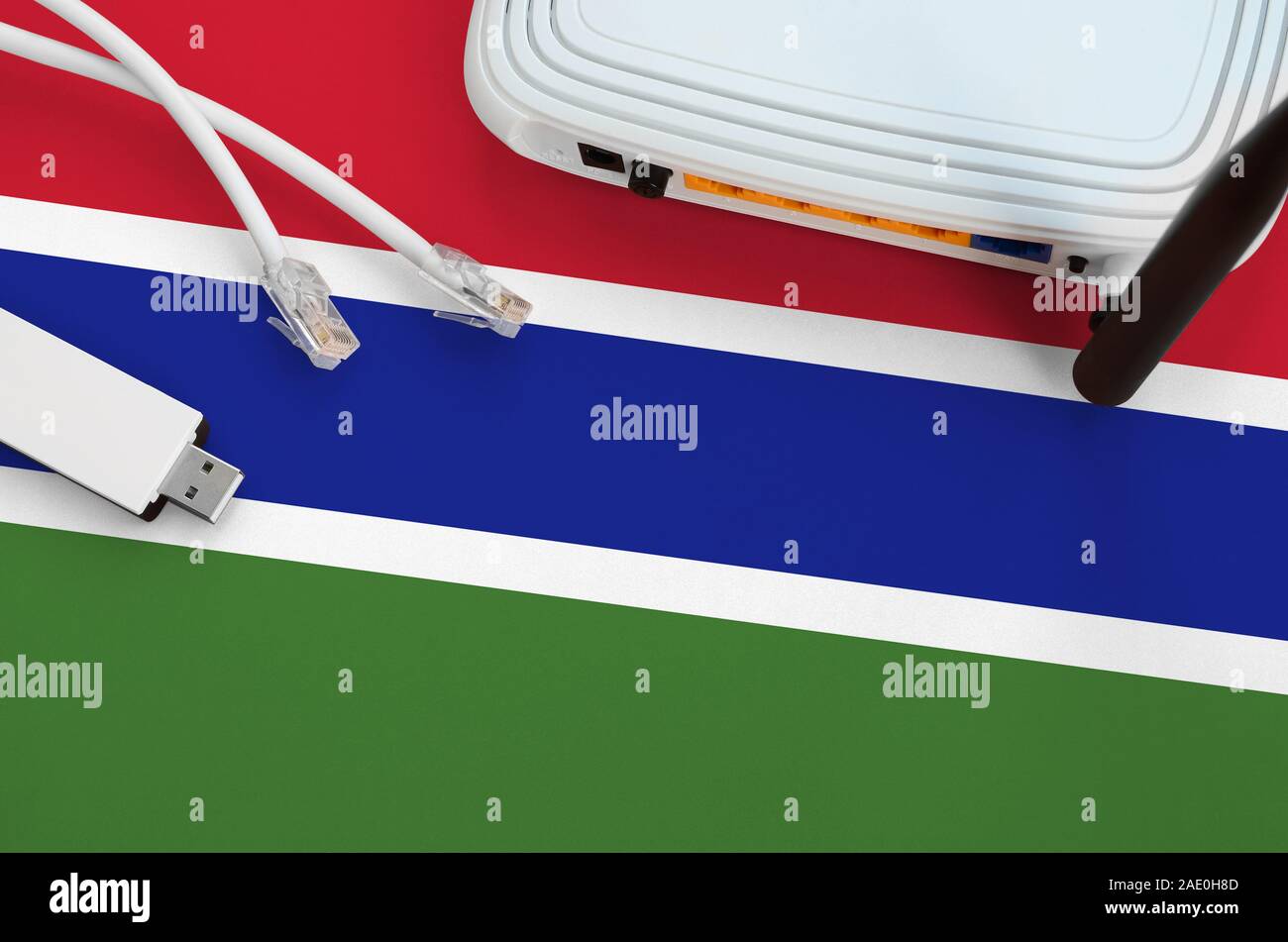 Gambia flag depicted on table with internet rj45 cable, wireless usb wi ...