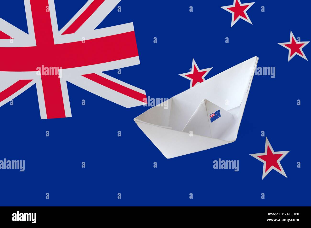 New Zealand flag depicted on paper origami ship closeup. Oriental ...