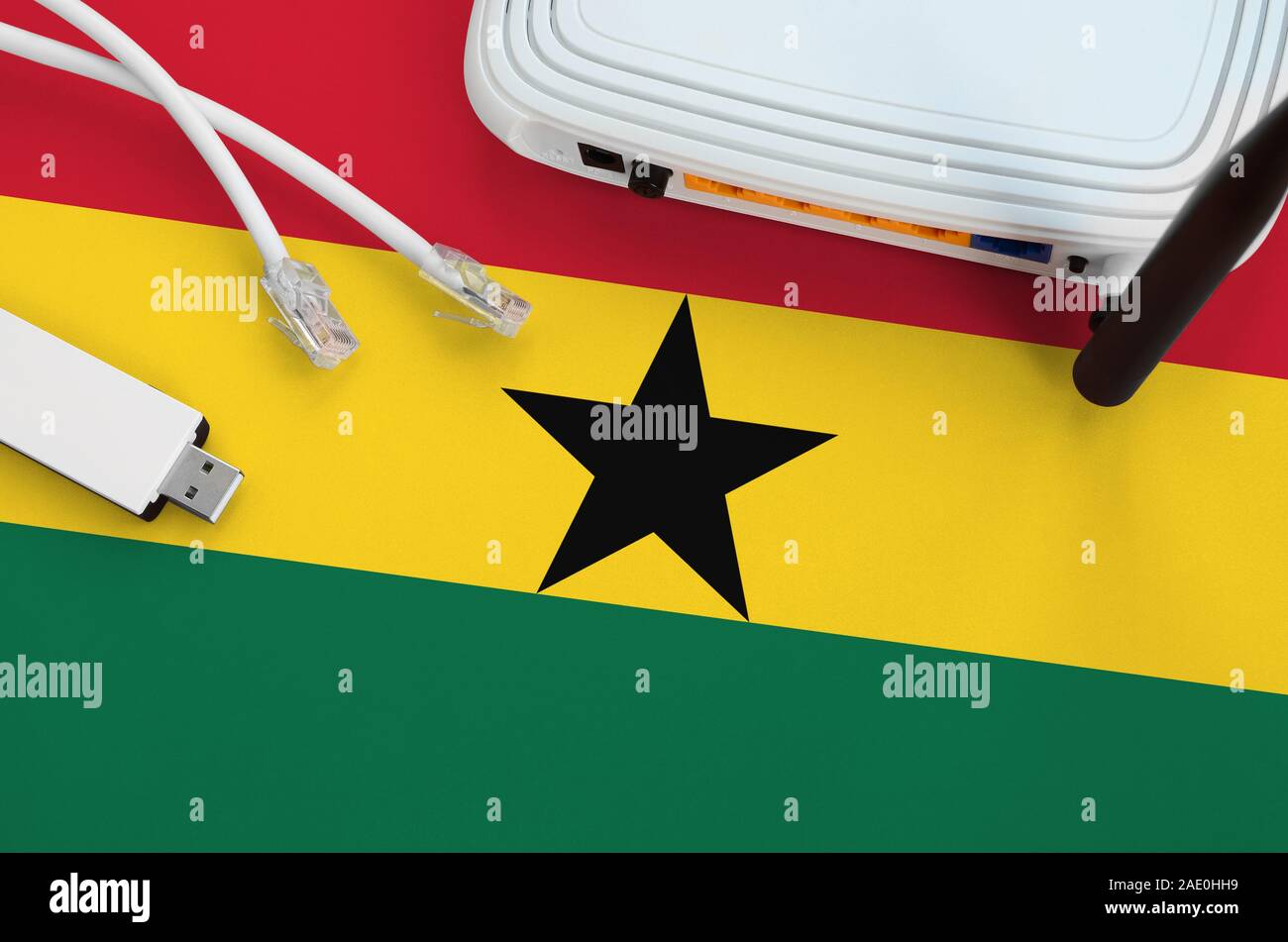 Ghana flag depicted on table with internet rj45 cable, wireless usb wi ...
