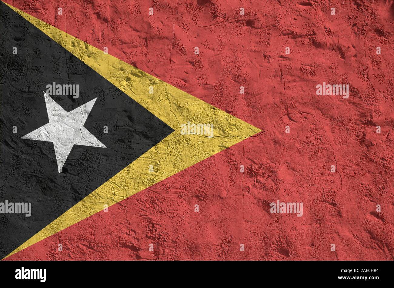 Timor Leste flag depicted in bright paint colors on old relief ...