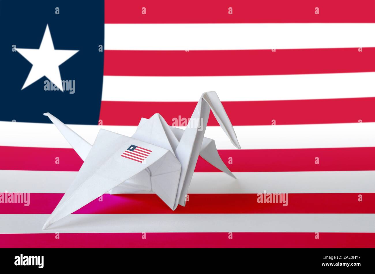 Liberia flag depicted on paper origami crane wing. Oriental handmade ...