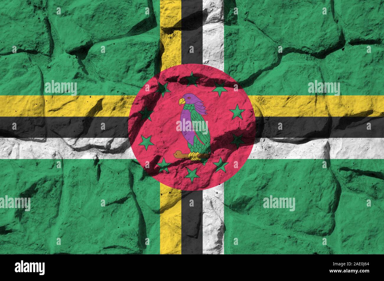 Dominica flag depicted in paint colors on old stone wall close up ...
