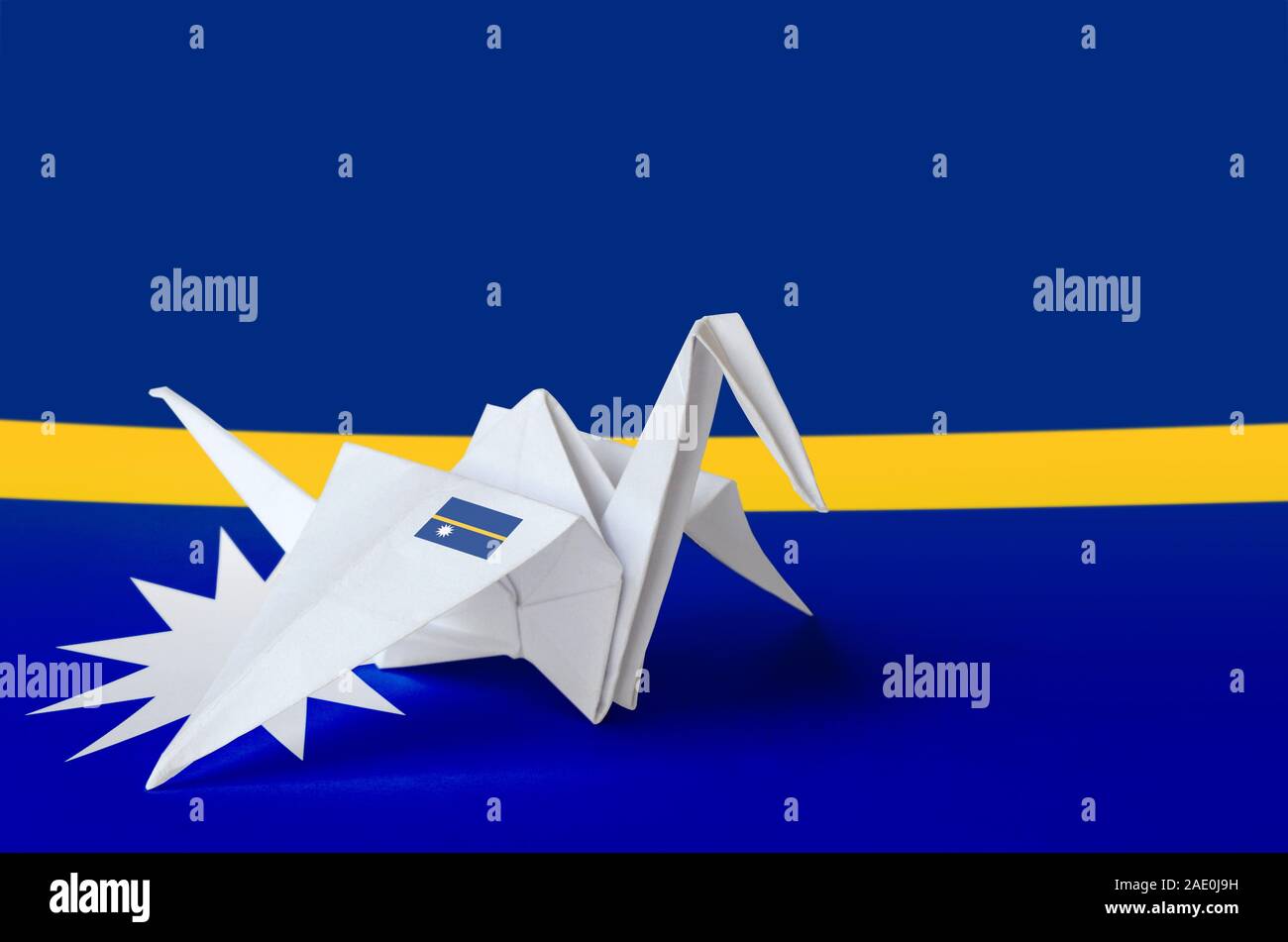 Nauru flag depicted on paper origami crane wing. Oriental handmade arts ...