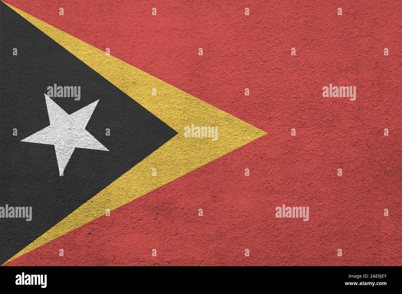 Timor Leste flag depicted in bright paint colors on old relief ...