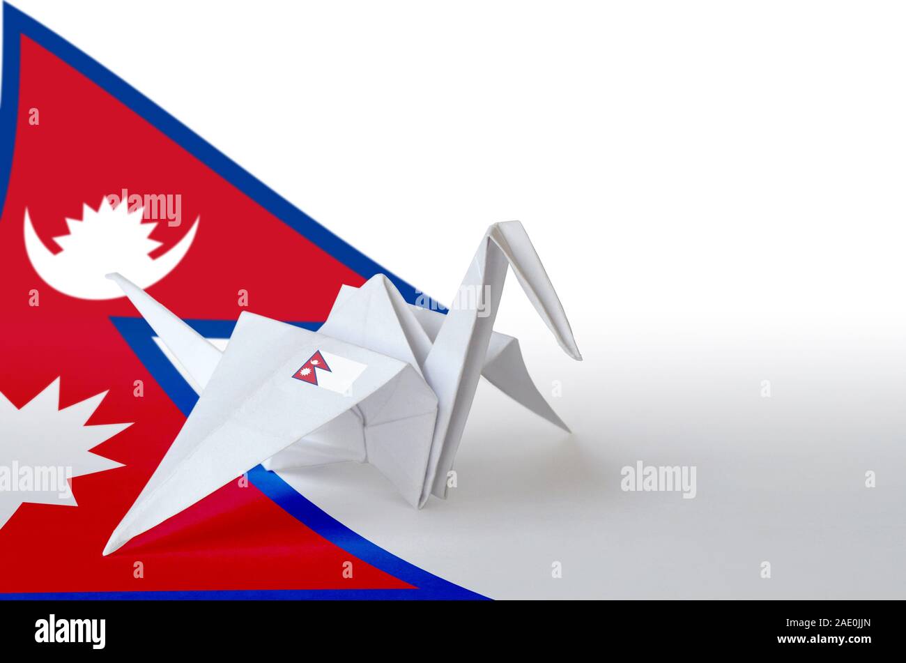 Nepal flag depicted on paper origami crane wing. Oriental handmade arts ...