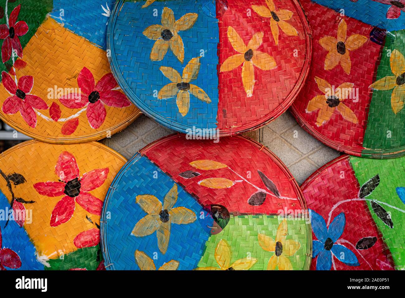 Colorfully painted conical farmer's hats with flower motifs and bright ...