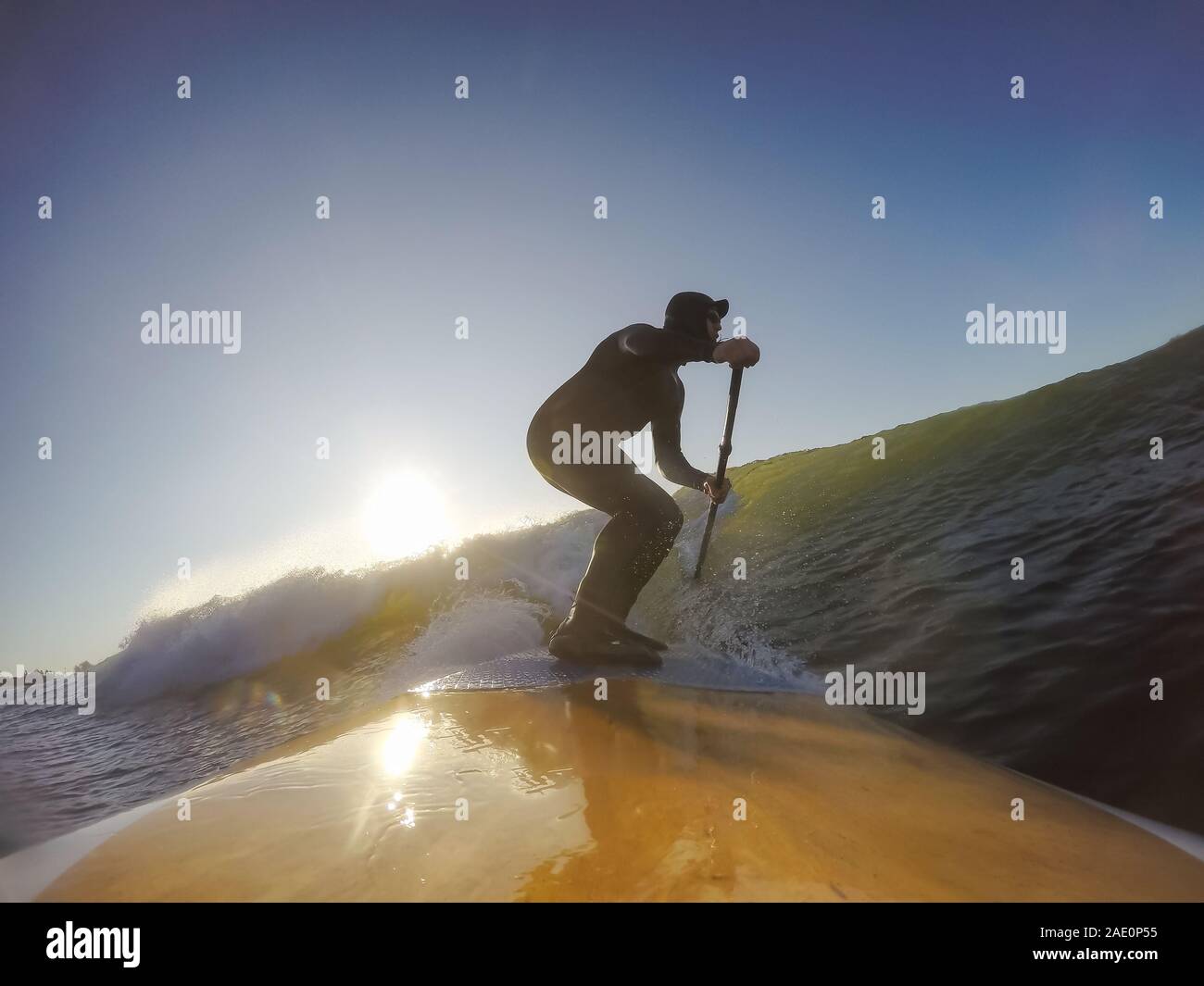 Adventurous Man Surfer on a paddle board is surfing in the ocean during ...