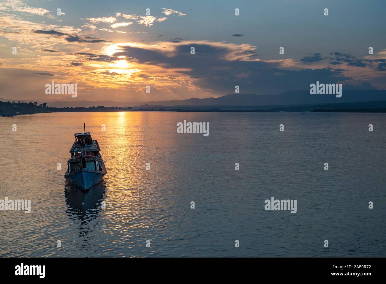 River boat cruises on the Chindwin River heading for shore as sunset ...