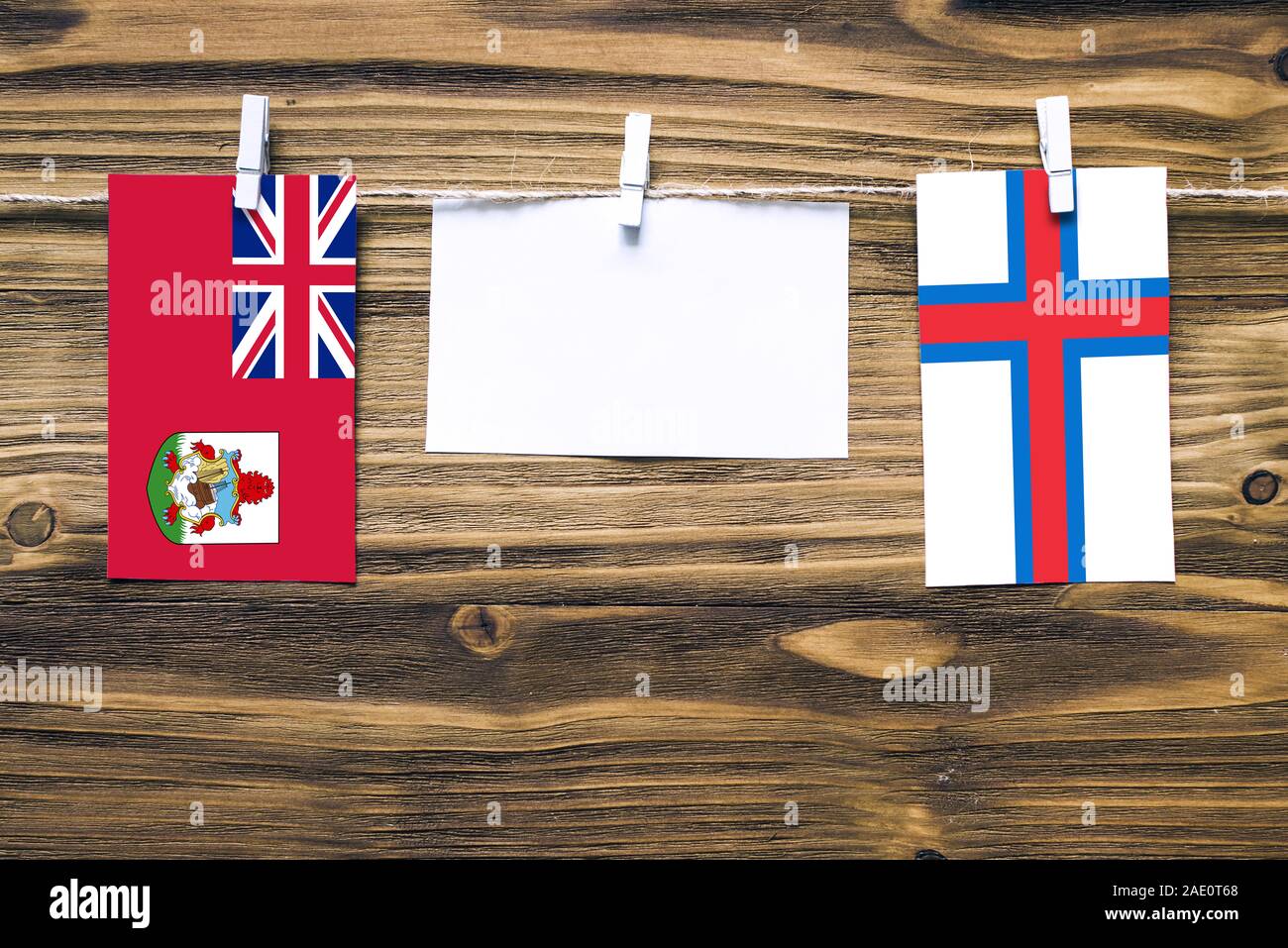 Hanging flags of Bermuda and Faroe Islands attached to rope with ...