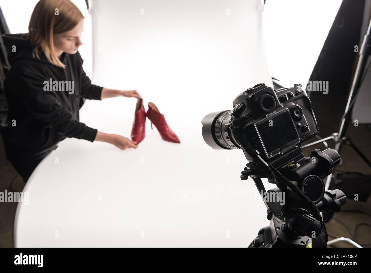 photographer making commercial photo shoot of female red heel shoes on ...
