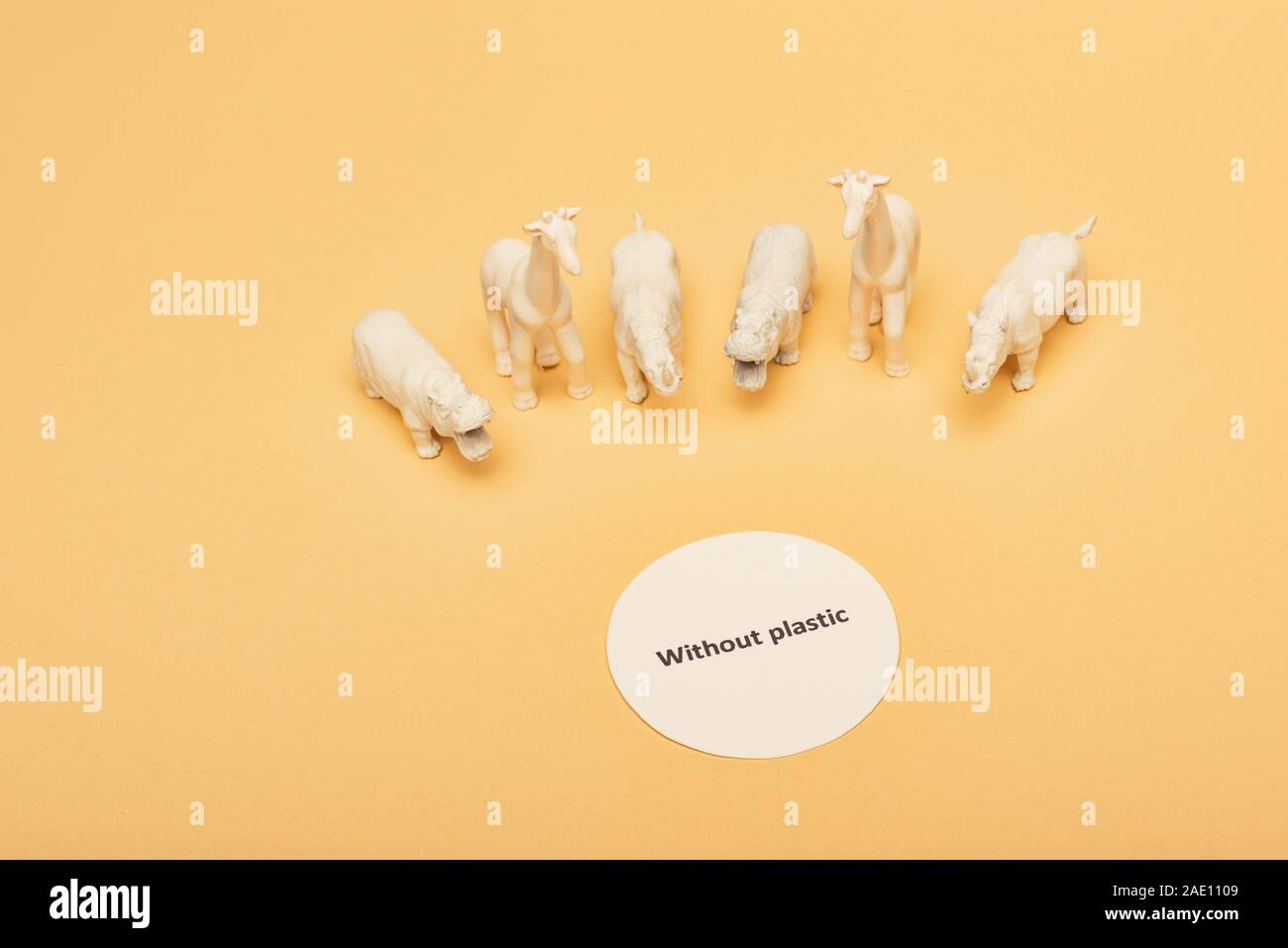 White toy animals with lettering without plastic on card on yellow ...
