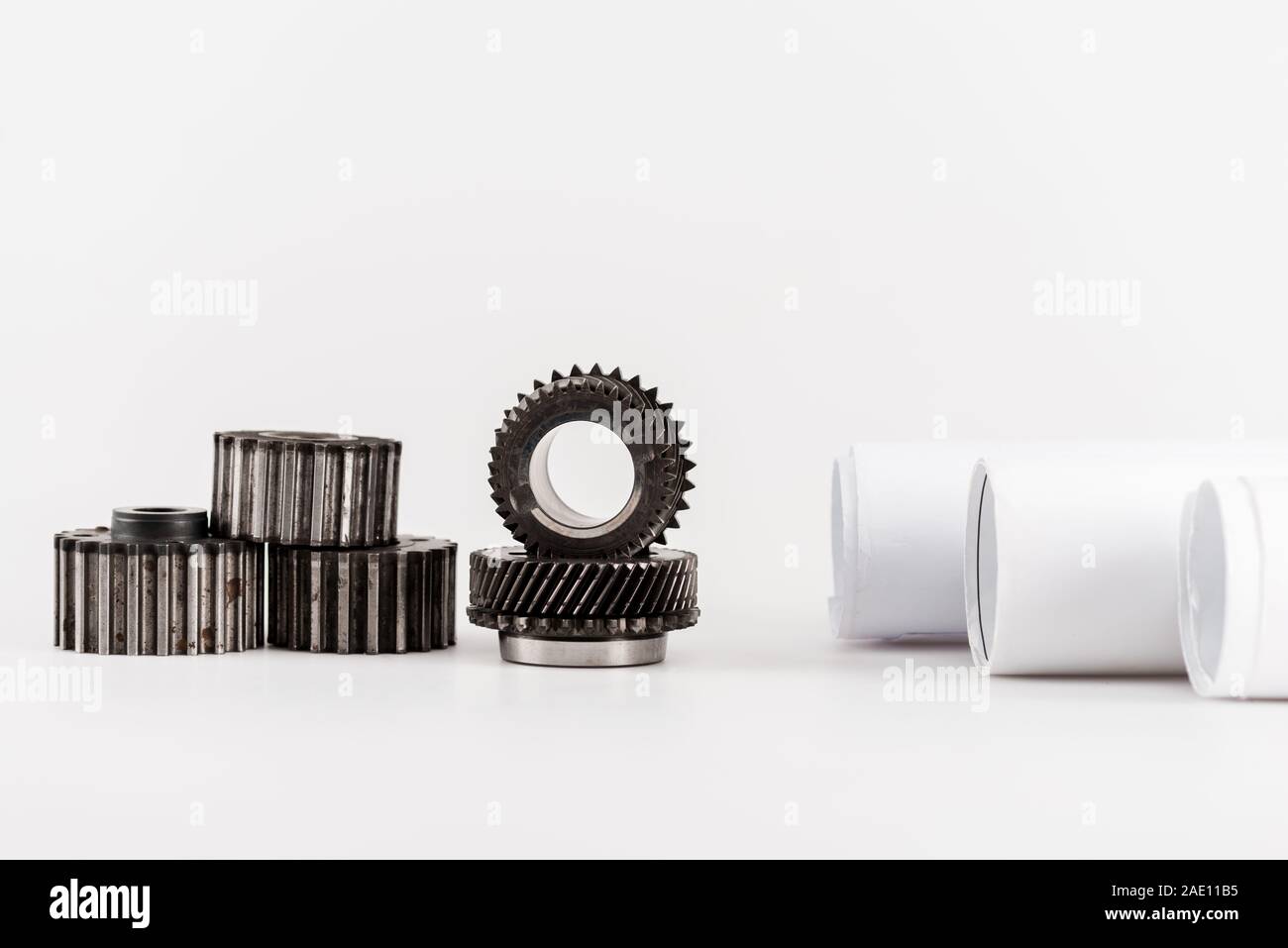 metal round gears near rolled blueprints on white background Stock ...