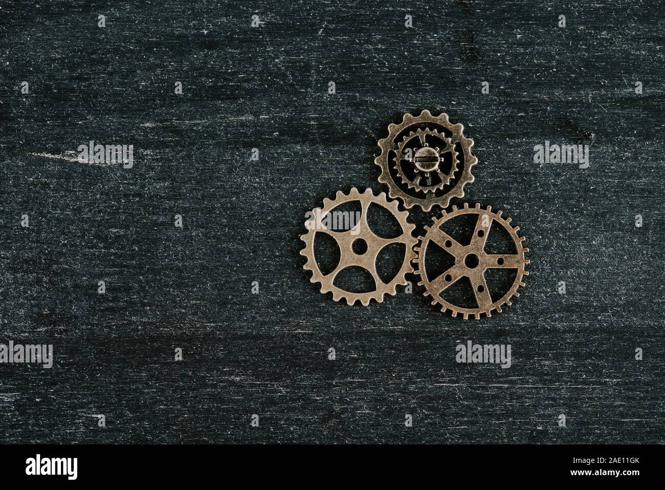 top view of vintage metal gears on dark wooden background with copy ...