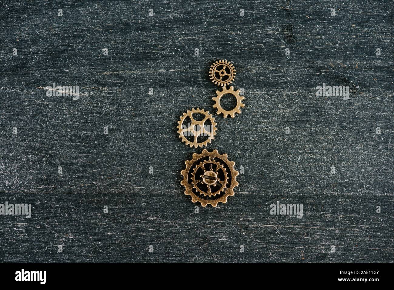 top view of vintage metal gears on dark wooden background with copy ...