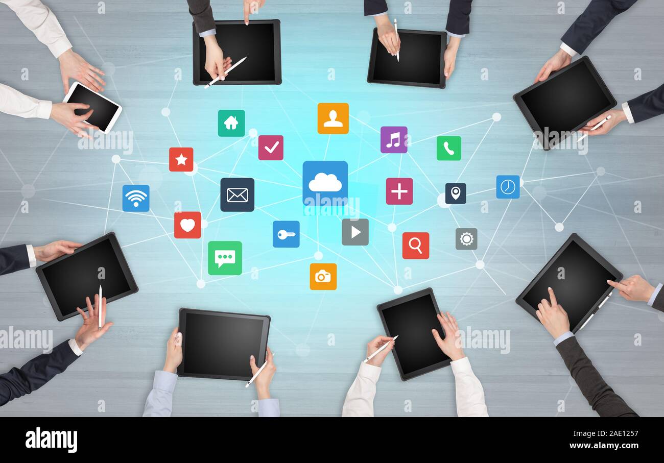 Group of people with devices in hands working in team on tablets ...