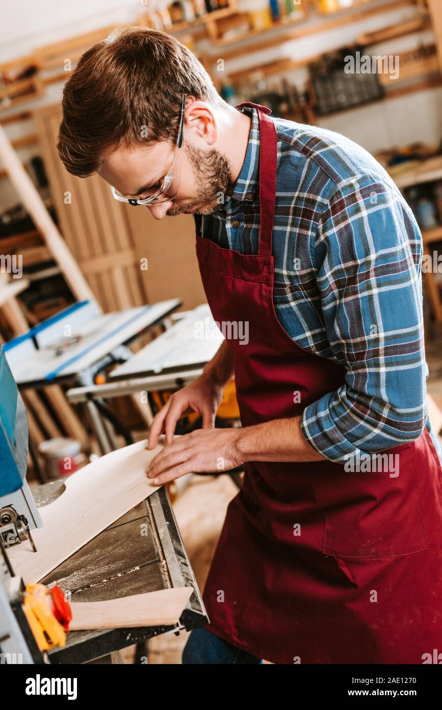 carpenter in safety glasses and apron using cnc machine Stock Photo - Alamy