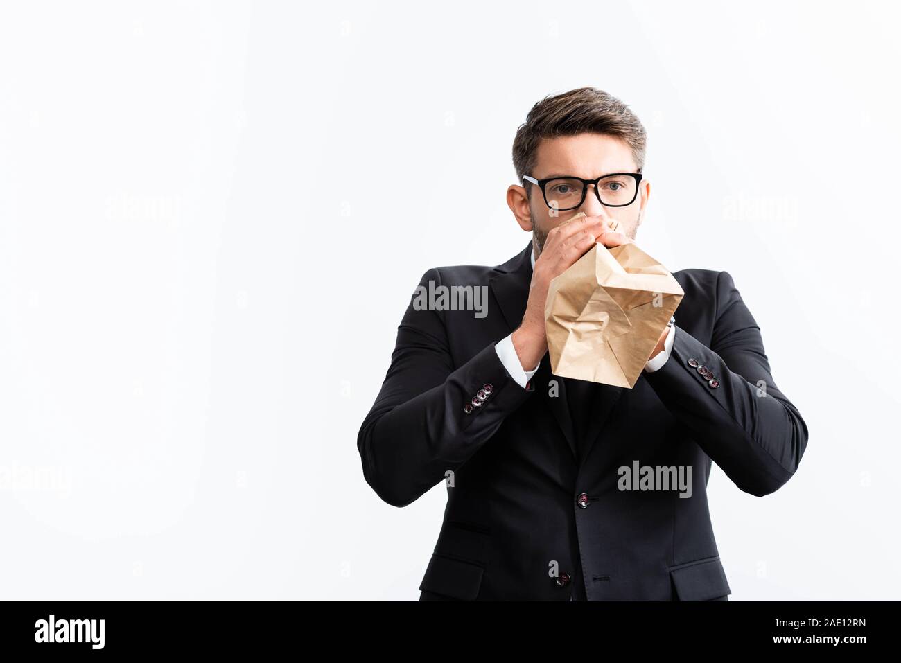 scared businessman in suit breathing in paper bag during conference ...