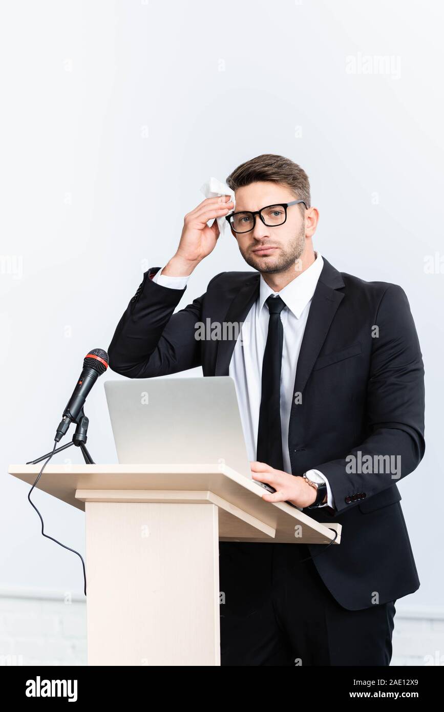 scared businessman in suit standing at podium tribune and holding ...