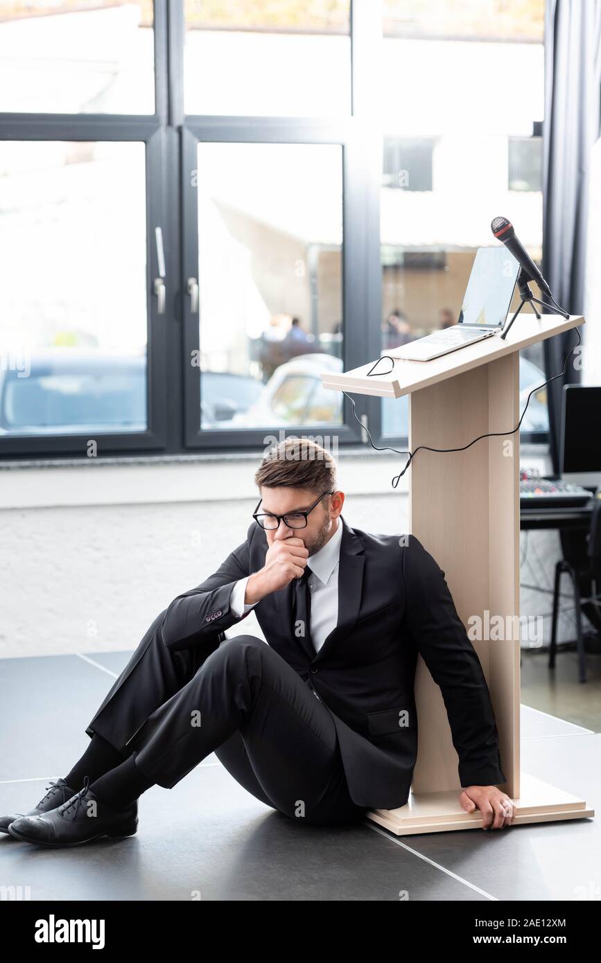 scared businessman in suit sitting on floor during conference Stock ...