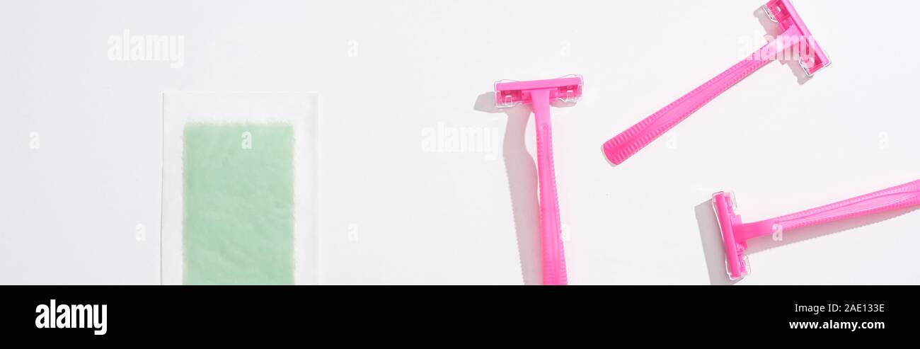 top view of female pink razors and depilation stripe on white ...