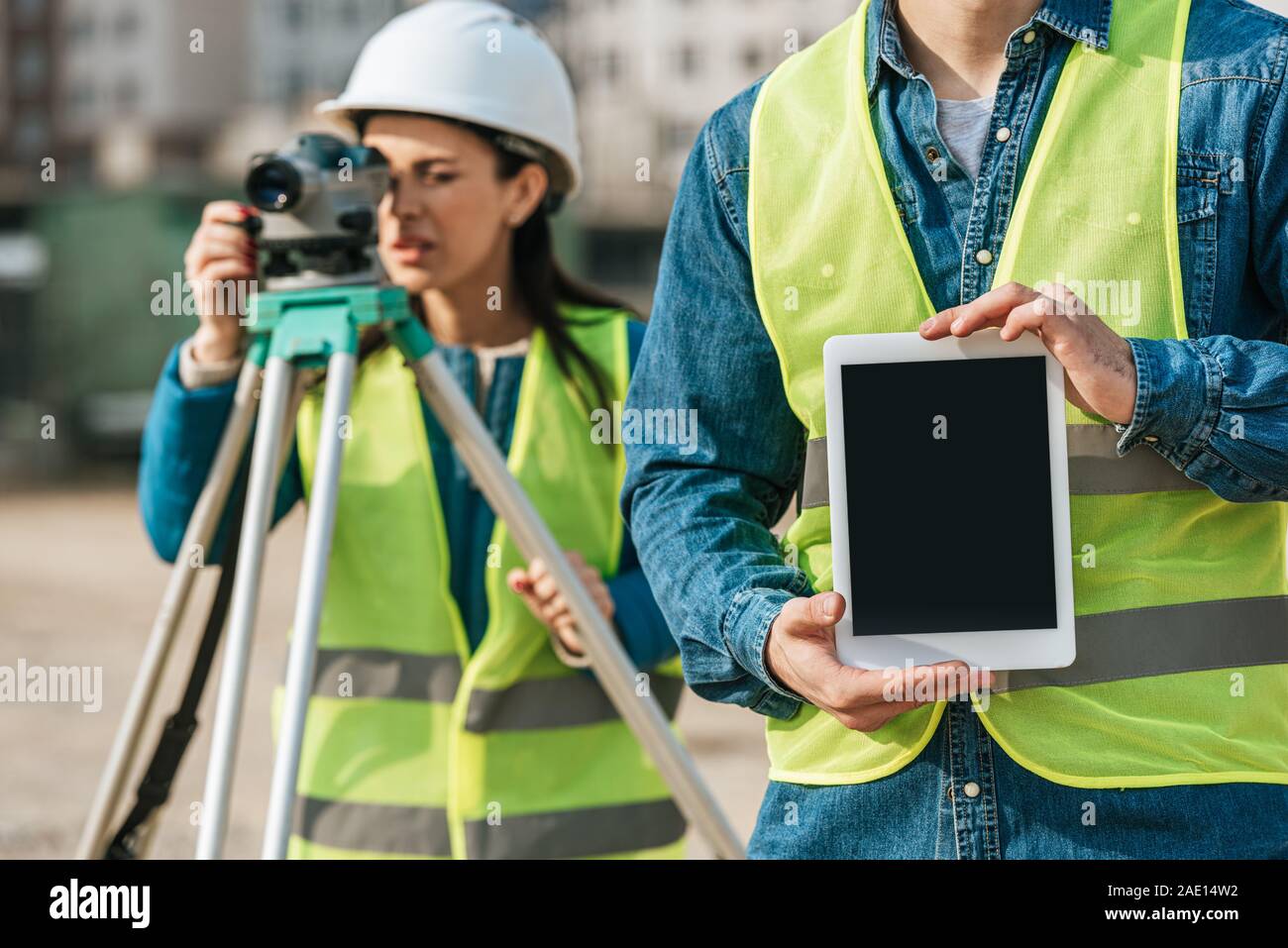 Cropped view of surveyor holding digital tablet with blank screen and ...