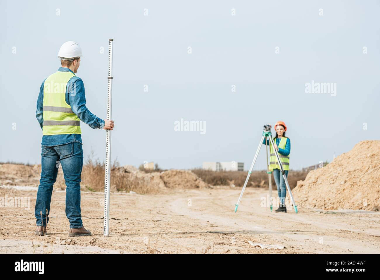 Surveyors using digital level and survey ruler on dirt road Stock Photo ...