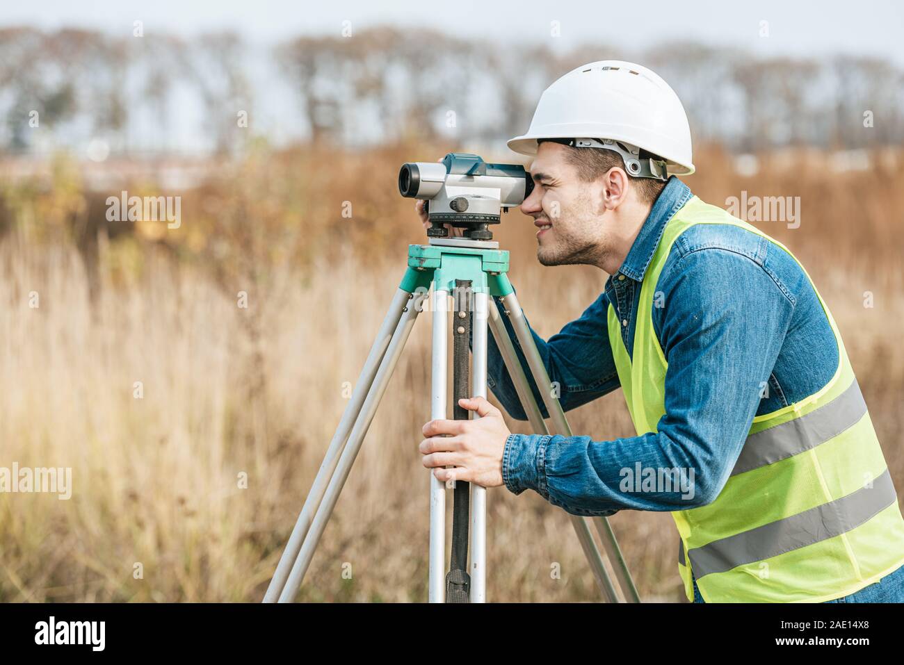 Side view of surveyor looking through digital level in field Stock ...