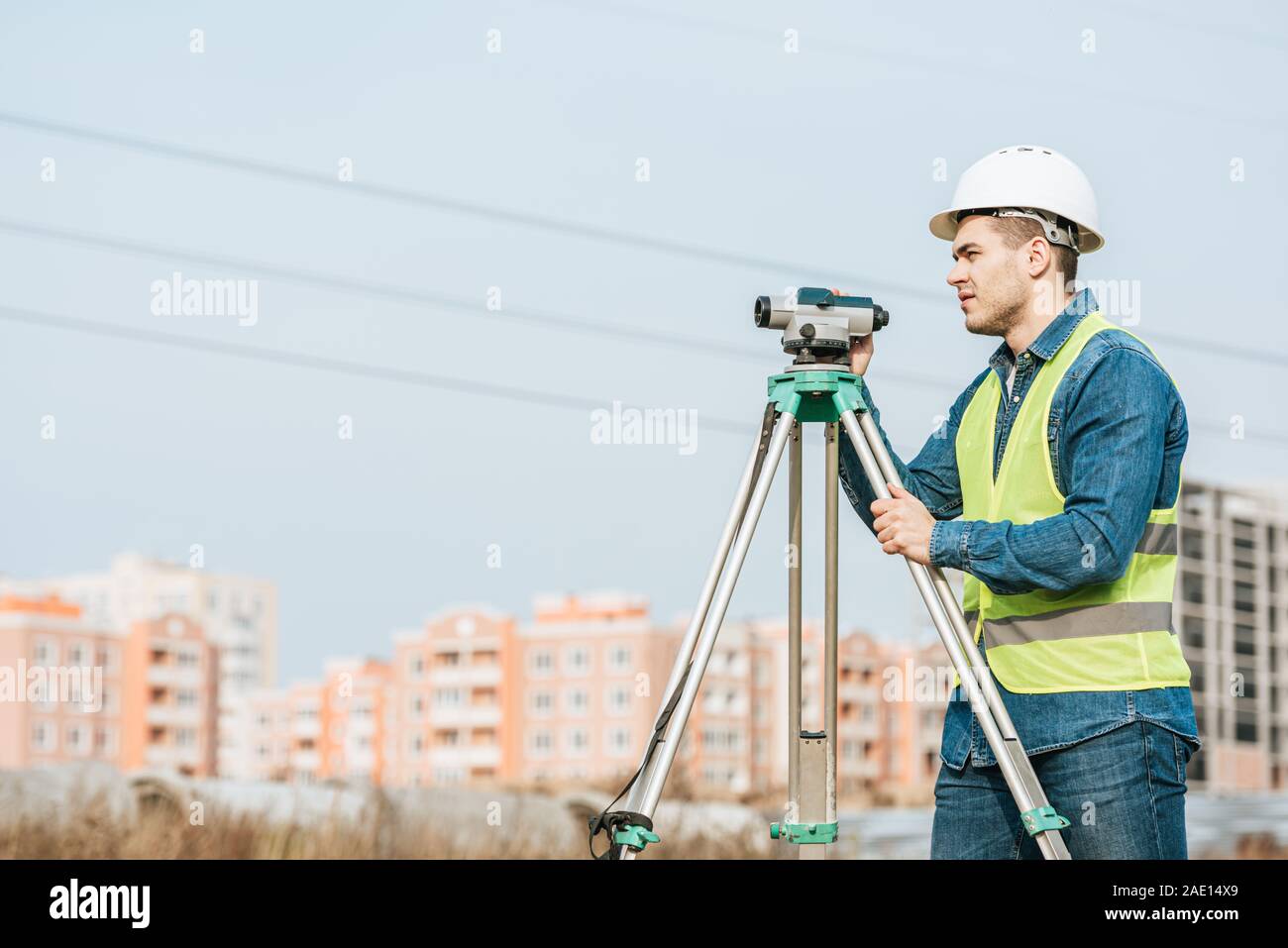 Side view of surveyor with digital level looking away Stock Photo - Alamy