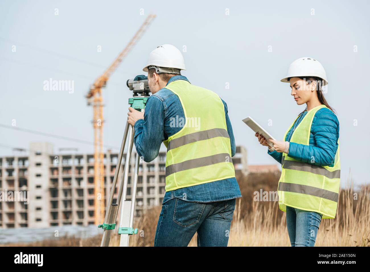 Surveyors working with digital level and tablet in field Stock Photo ...