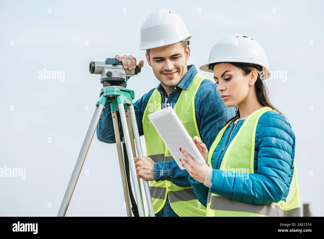 Surveyors with with digital level looking at tablet Stock Photo - Alamy