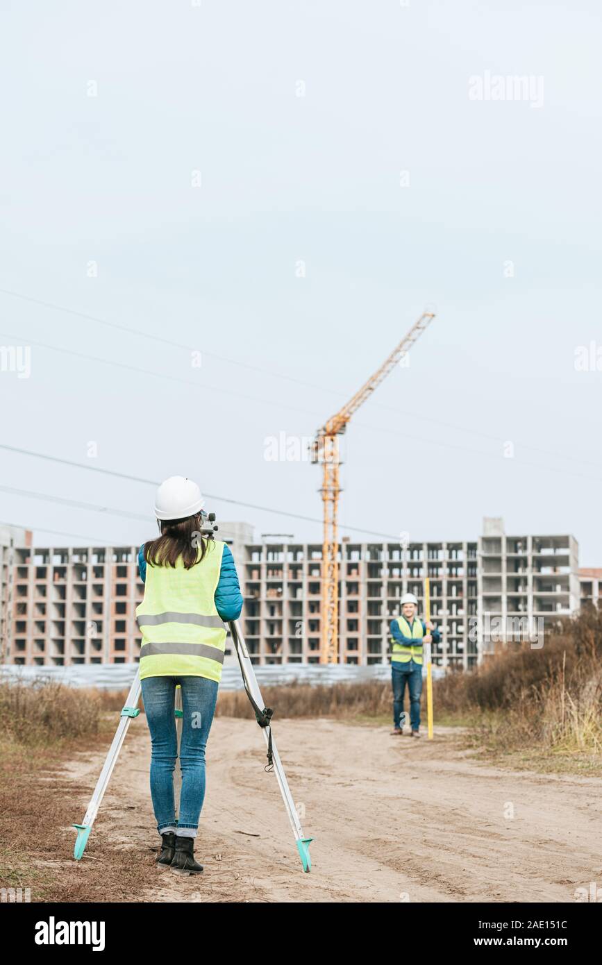 Surveyors measuring land on dirt road of construction site Stock Photo ...