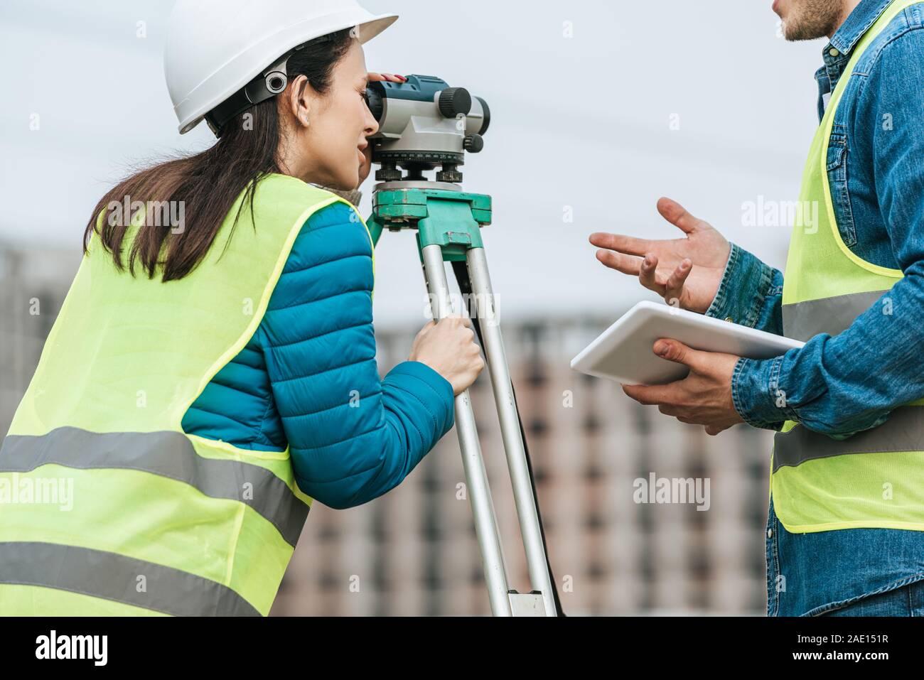 Cropped view of surveyors working with digital level and tablet Stock ...