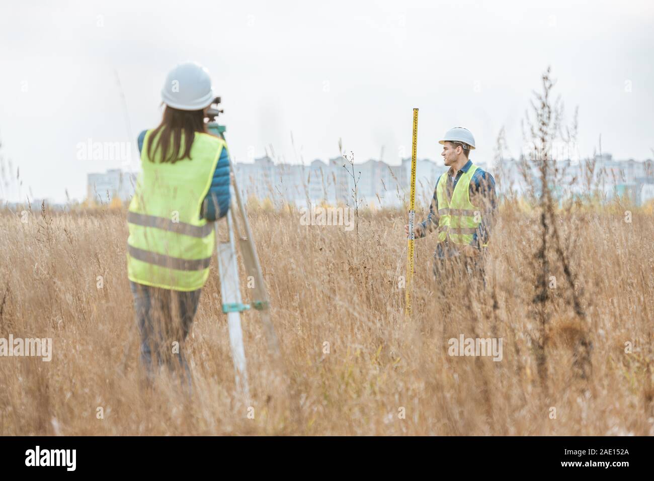 Surveyors working with digital level and ruler in field Stock Photo - Alamy