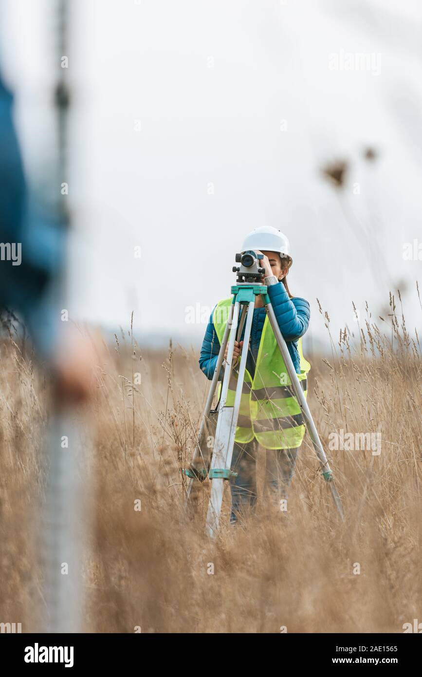Selective focus of surveyors measuring land with digital level and ...