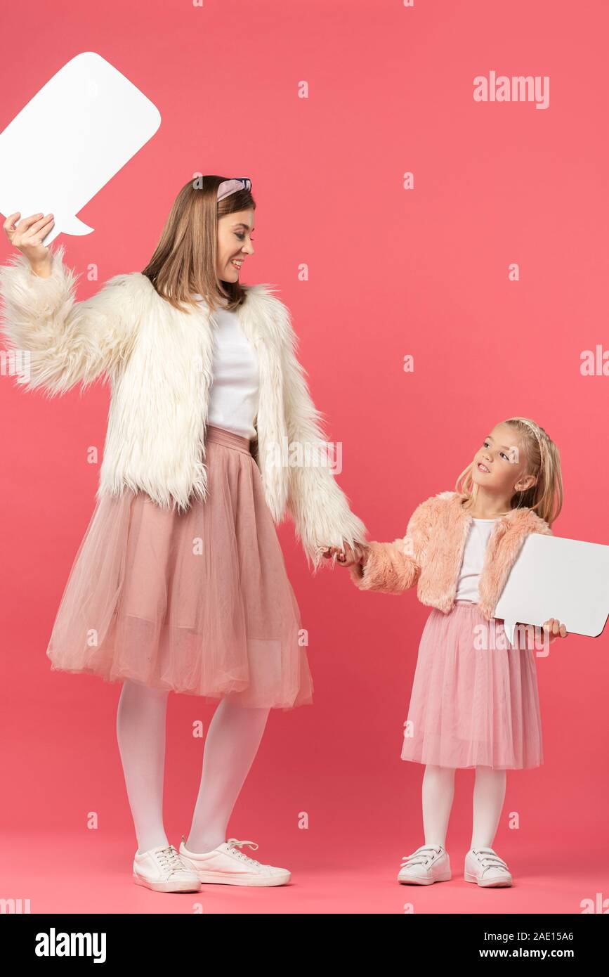 smiling daughter and mother holding speech bubbles on pink background ...