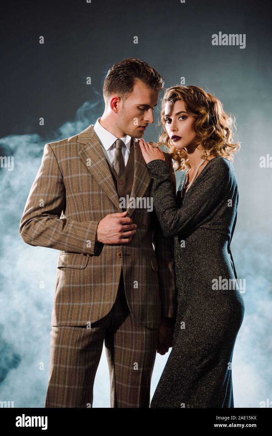 attractive woman standing with handsome gangster on black with smoke ...